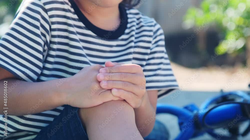 Sad little girl sitting on the ground after falling off her bike at ...