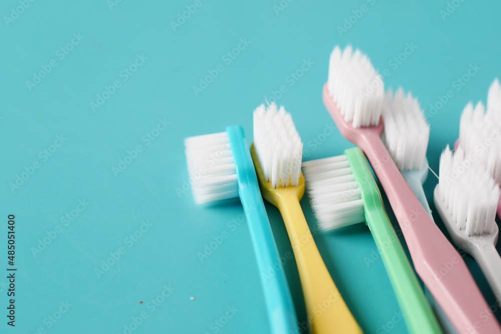 colorful toothbrushes on light green background Stock Photo | Adobe Stock