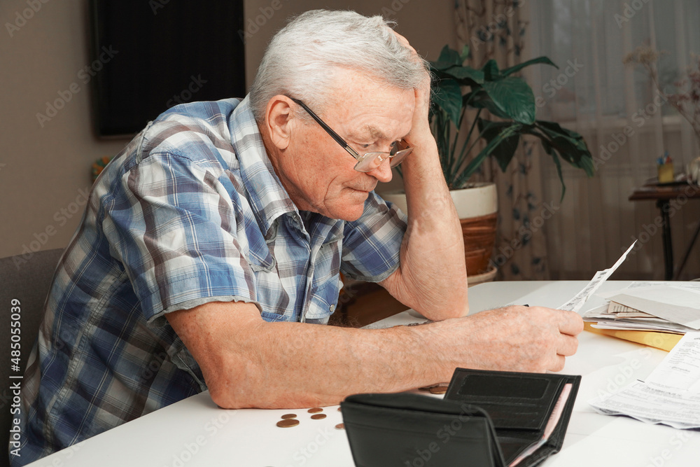 Upset depressed Senior man sitting at the table and calculating ...