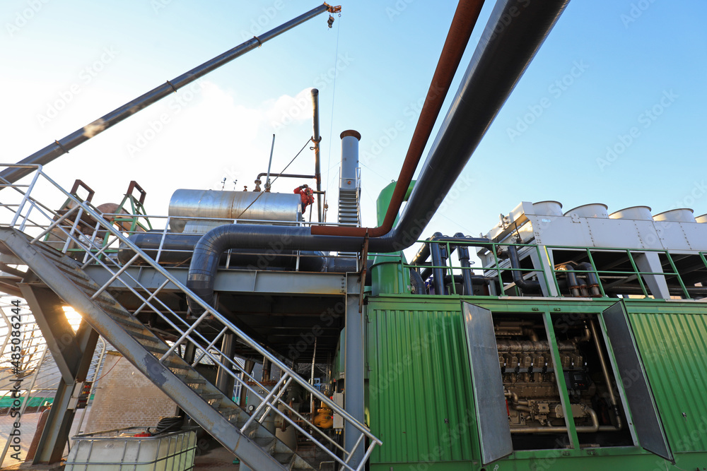 Workers are welding steam transmission pipes in a biogas power plant ...