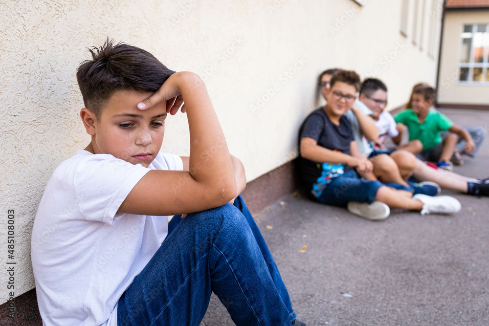 Group of schoolboys bullying a sad and upset looking boy. Stock Photo ...