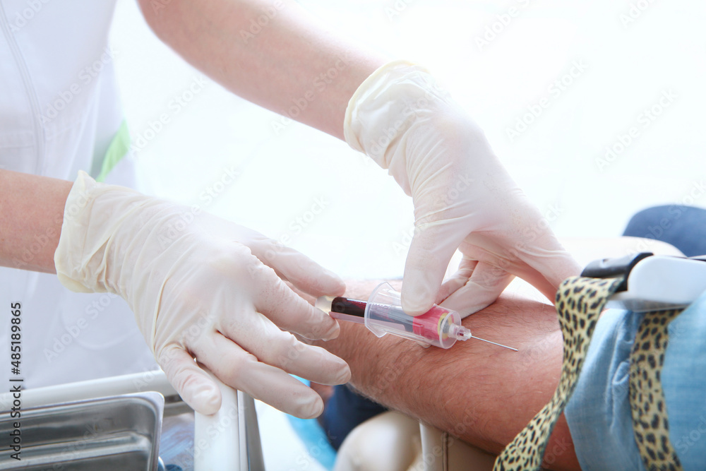 The patient gives blood for analysis to a medical laboratory. A syringe ...