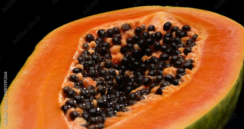 Macro of papaya cross-section rotating. Isolated on black background ...