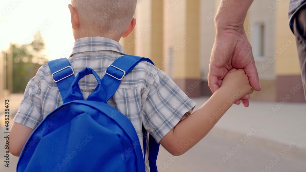 Schoolboy with school backpack goes to school with his dad. Happy ...