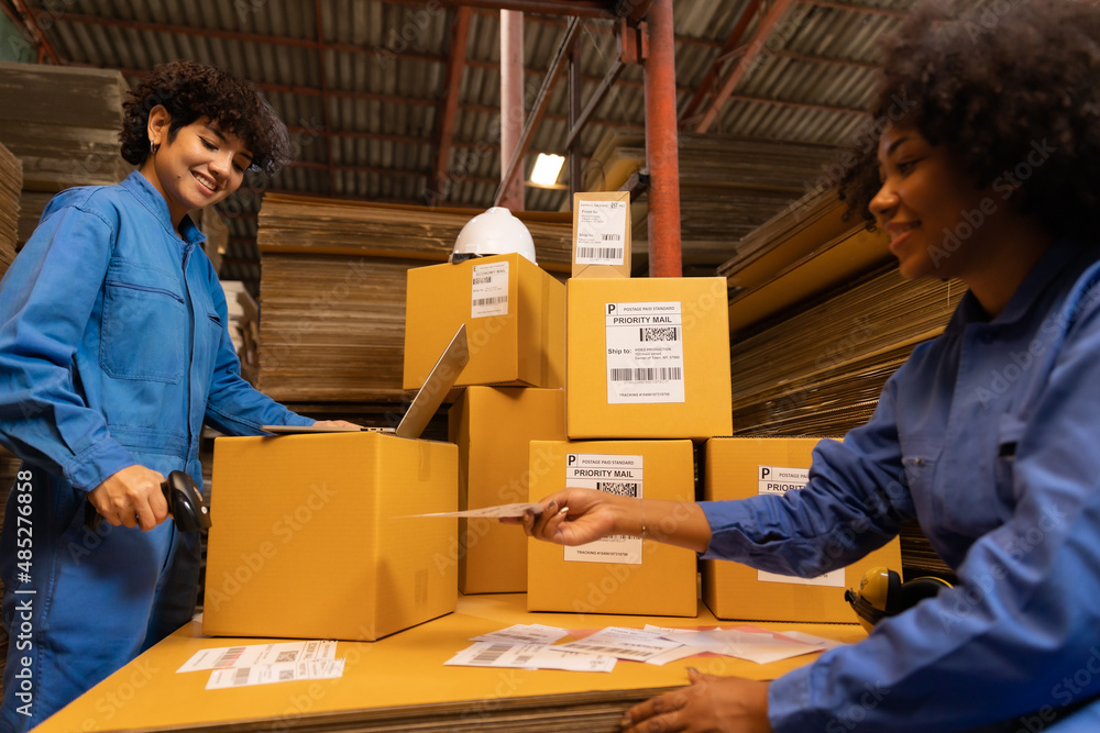 People working in storage, taking parcel and scanning barcode, putting ...