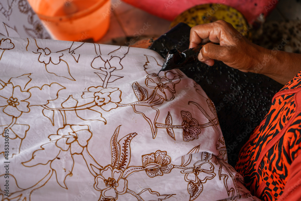 The technique of making batik by writing using a canting tool. Canting ...