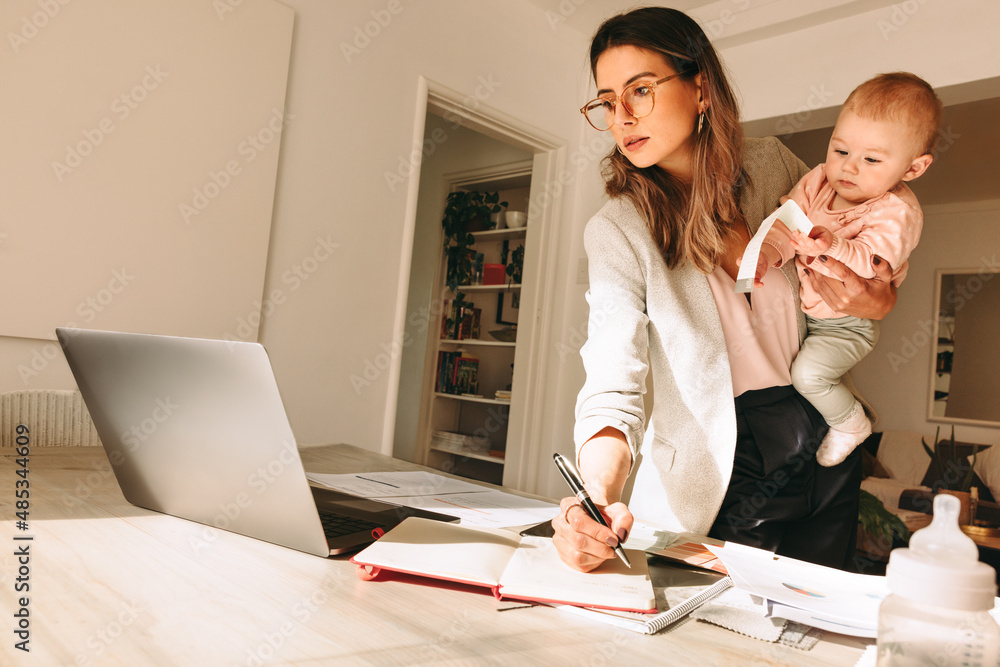 Multitasking mom working in her home office Stock Photo | Adobe Stock