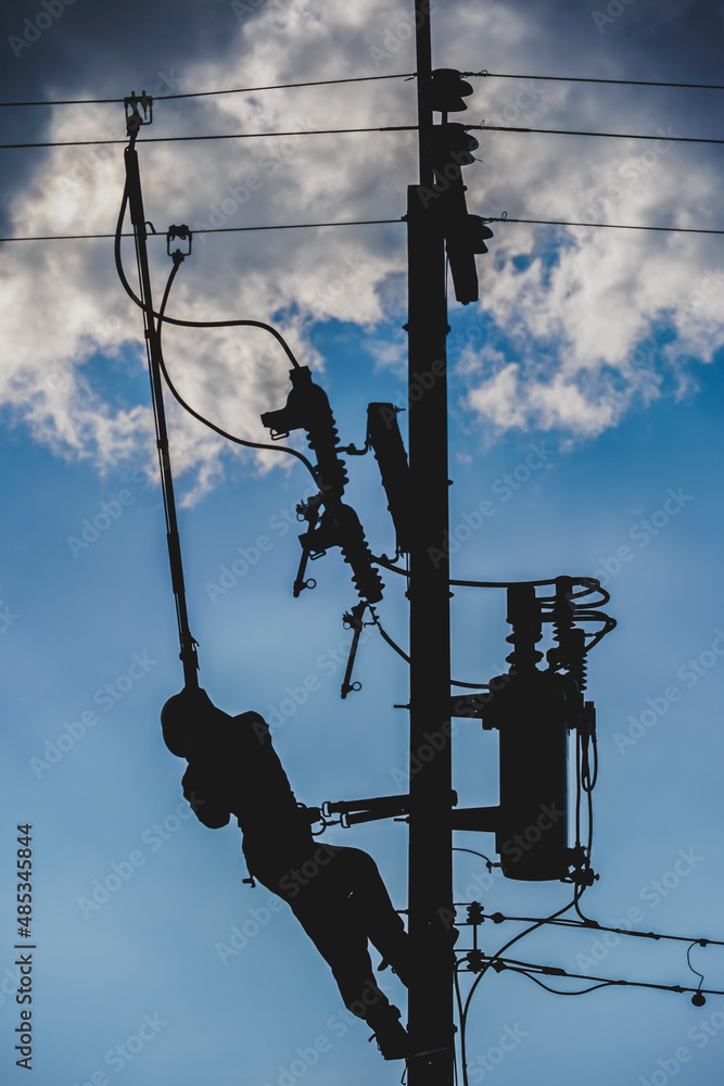 The silhouette of power lineman replacing a transformer and hotline ...