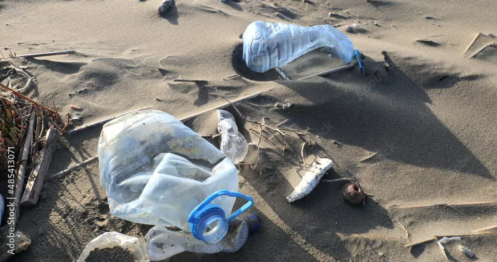 Plastic and garbage on a beach on a sunny day. Protect nature and clean ...