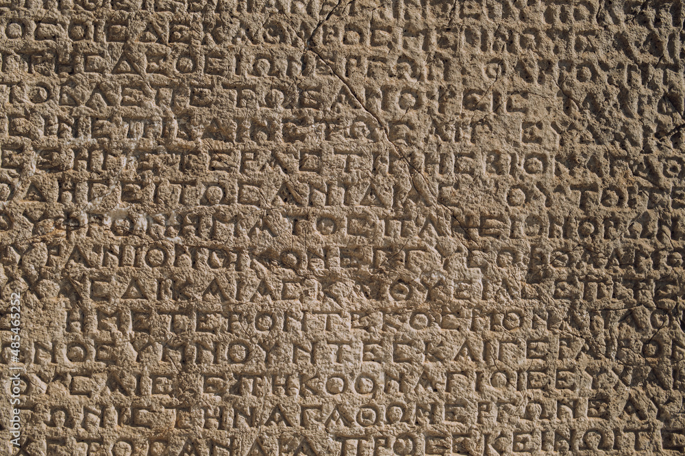 Ancient greek inscriptions on the wall of archeological ruins close-up ...