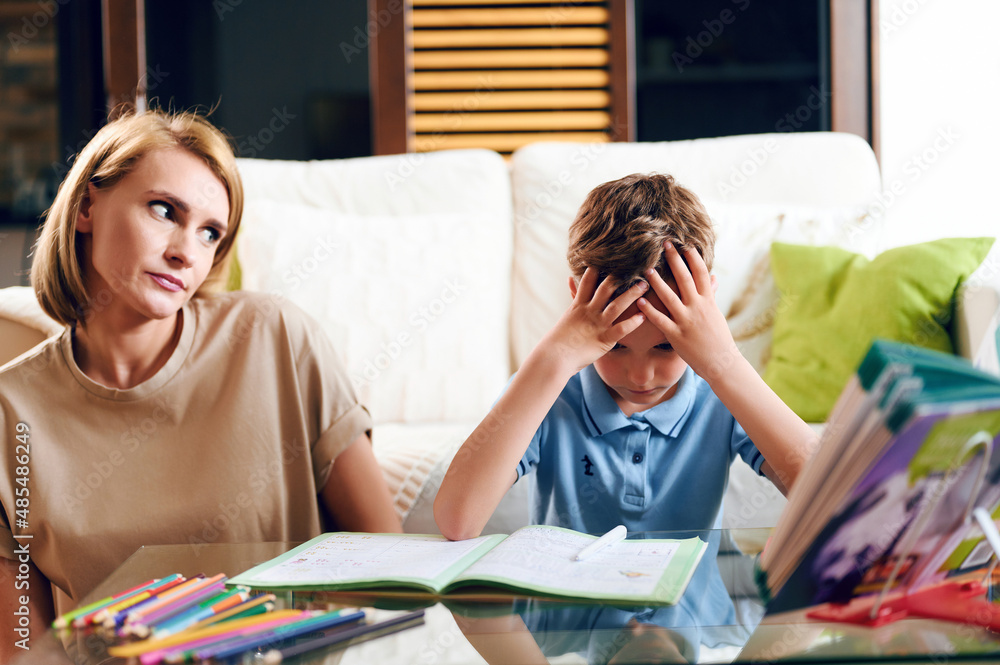 Teenage schoolboy having problems in finishing homework. Displeased ...
