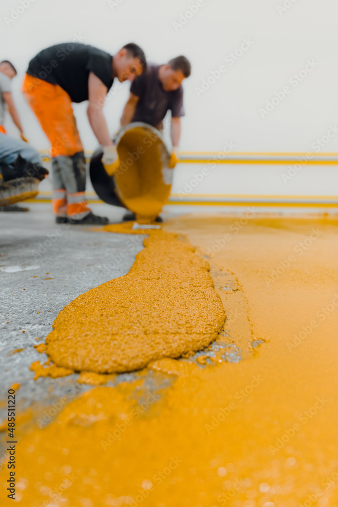 Professional construction worker applying floor paint or a new layer ...