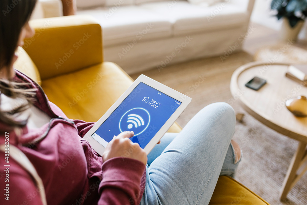 Young woman controlling smart home through tablet PC Stock Photo ...
