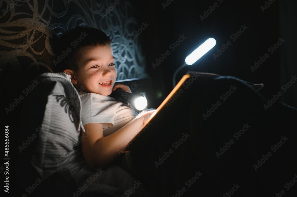 Child reading book in bed. Kids read at night. Little boy with fairy ...