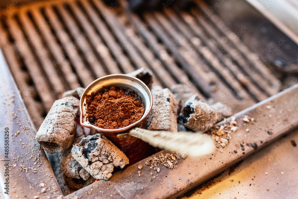 Brewing a turkish style coffee in brassy cezve on a charcoal stove in ...