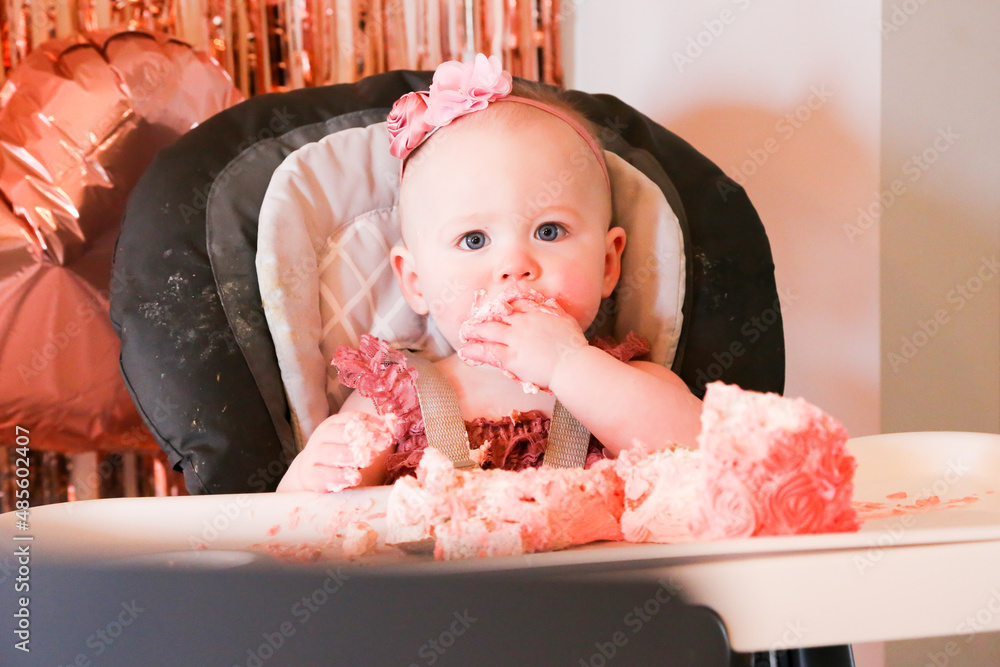 Cute birthday girl celebrating her one year birthday by messily eating ...
