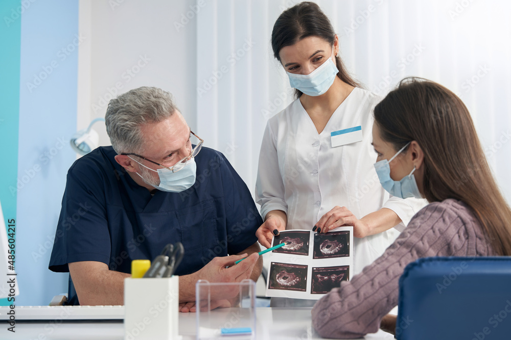 Diagnostician and gynecologist demonstrating fetal ultrasound images to ...