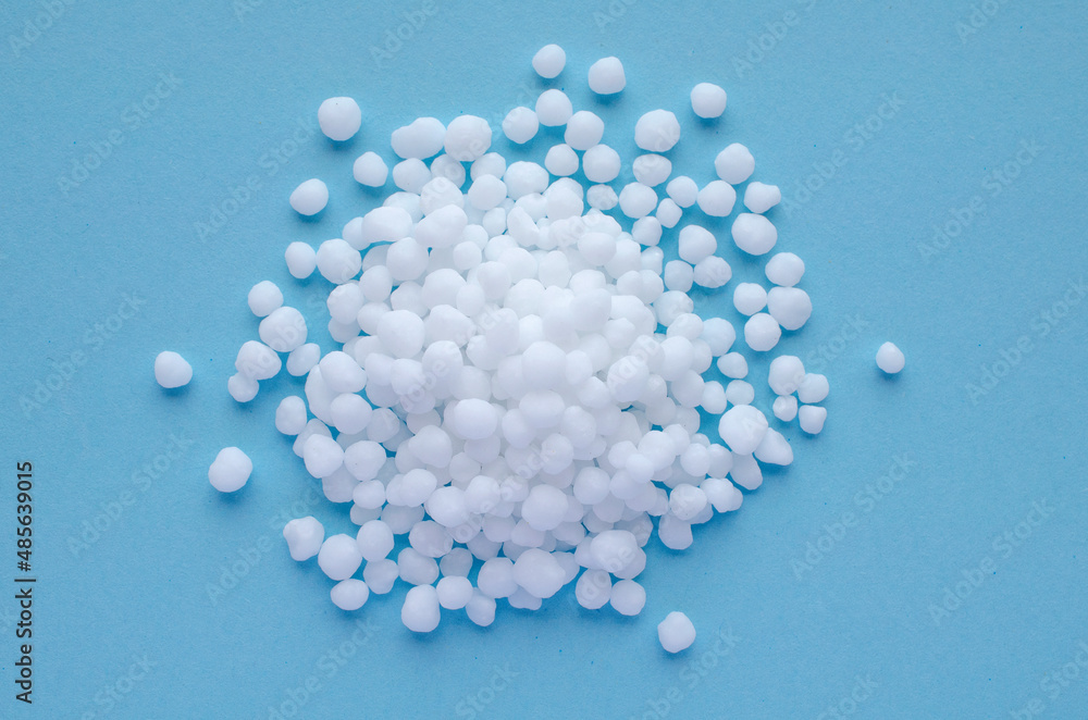 Urea granules on a blue background, space for text, top view. Nitrogen ...
