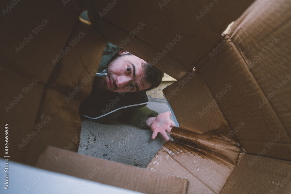 A young man throws out a cardboard box. View from the box on the man's ...