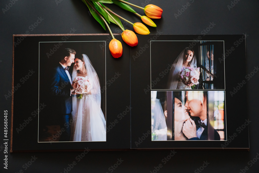 wedding photobook with photos of the newlyweds on a black background ...