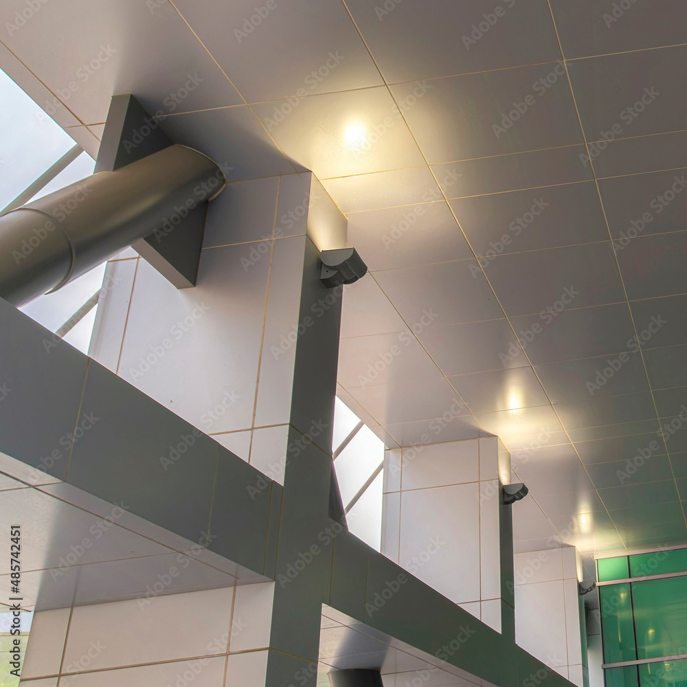 Square Light gray ceiling tiles and columns inside a building at Salt ...
