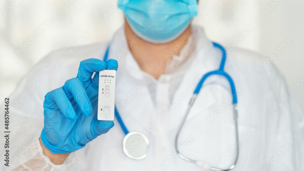 Hand in protective glove holds rapid antigen test for covid-19 in ...