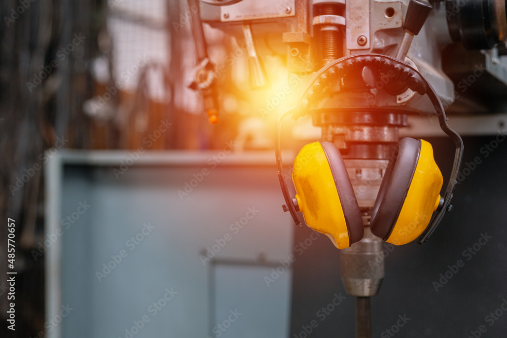Soundproof headphones for industry plants hanging on lathe in factory ...
