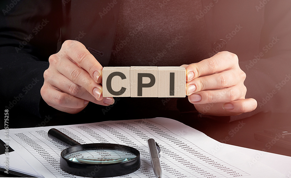 cpi text wooden cube blocks hand holding magnifying glass and chart on ...