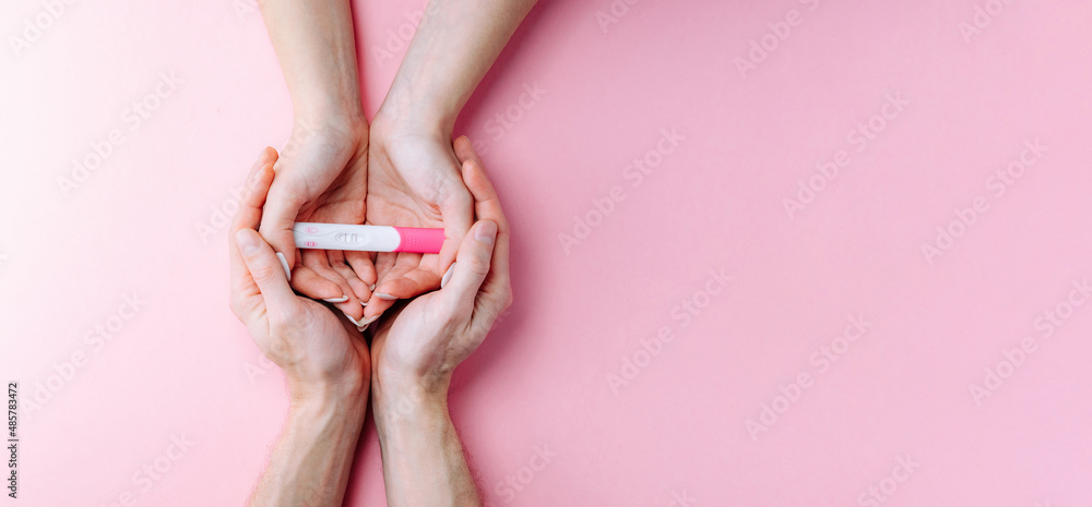 Pregnancy Test Kit Female Hand Hold Positive Pregnant Test With Silk Ribbon On Pink Banner