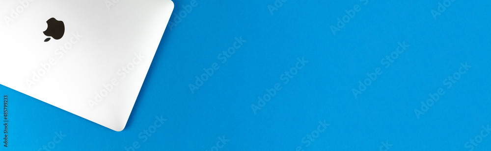 Apple Macbook on bright blue table background, banner with copy space ...