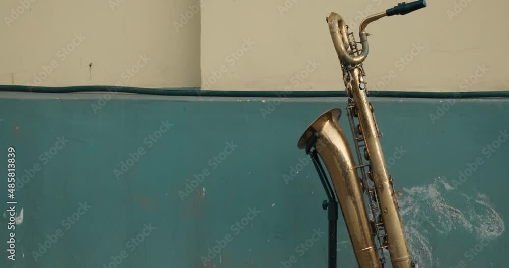 Large saxophone stands on a stand against the background of an old ...