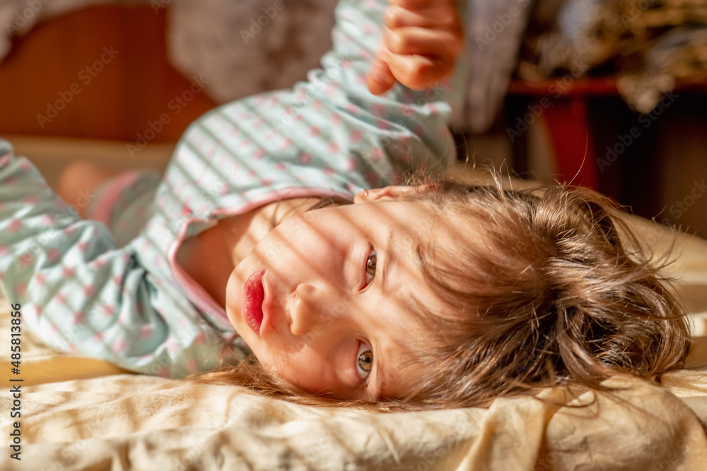 Funny portrait of beautiful girl in pajamas getting up or waking up ...