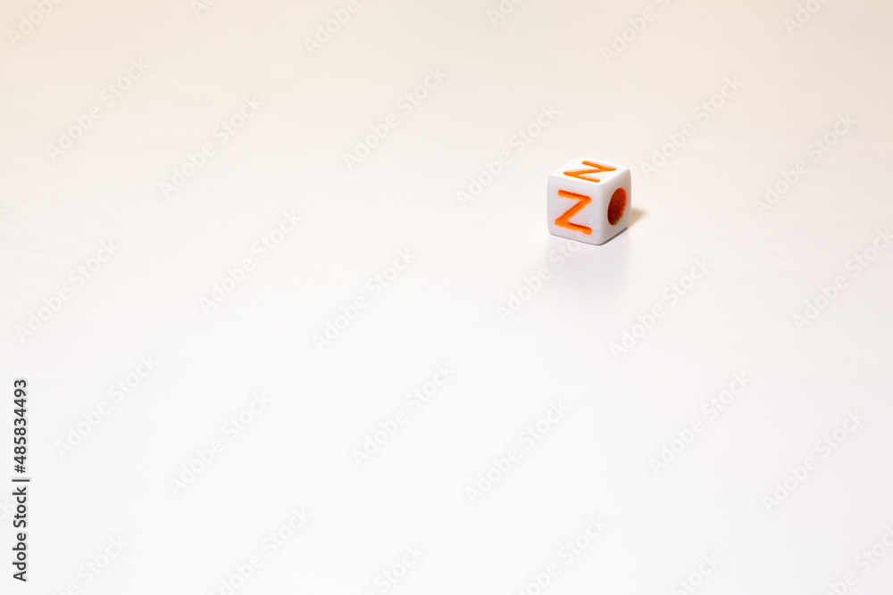 Cube shaped game dice with the orange letter Z on it on a white ...