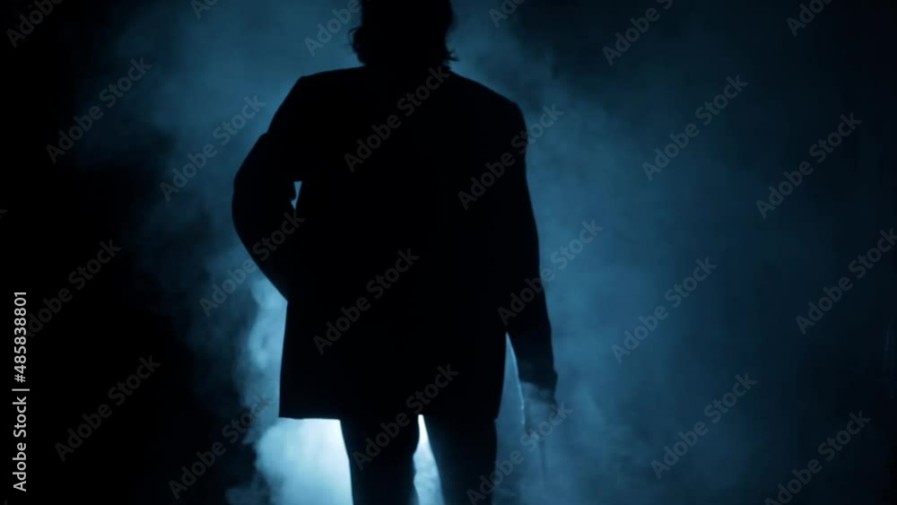 Dramatic cinematic shot of a gangster in a suit walking with a weapon ...