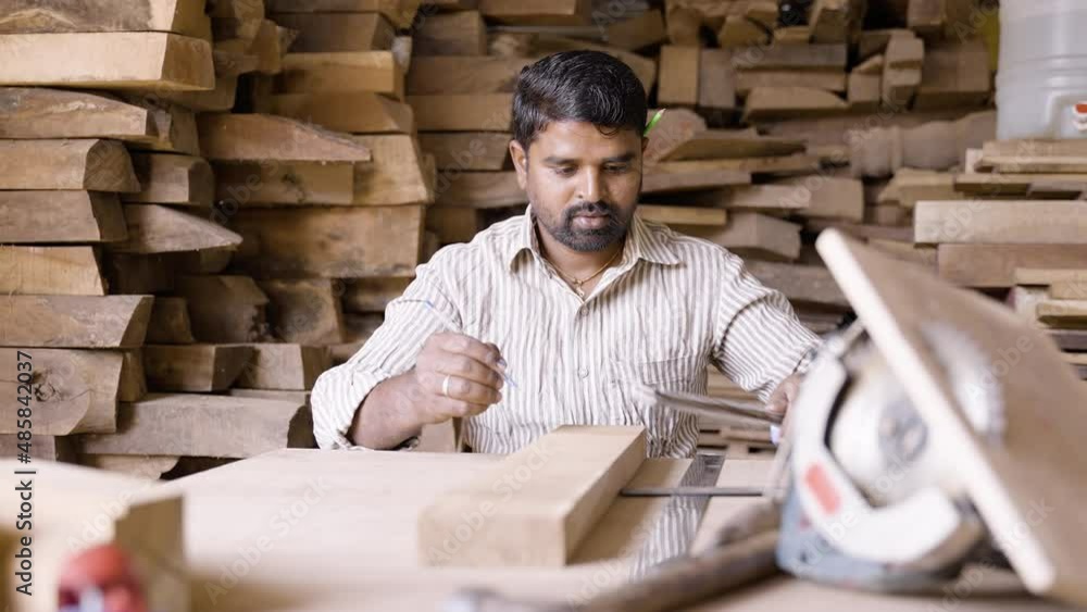 Young indian carpenter marking measurement wood with using steel square ...