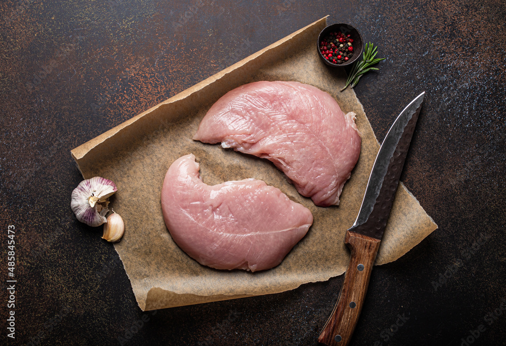 Turkey lean raw fillet on baking paper with rosemary, garlic and spices ...
