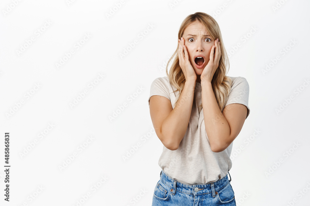 Shocked and scared blond woman staring terrified, horrified of smth ...