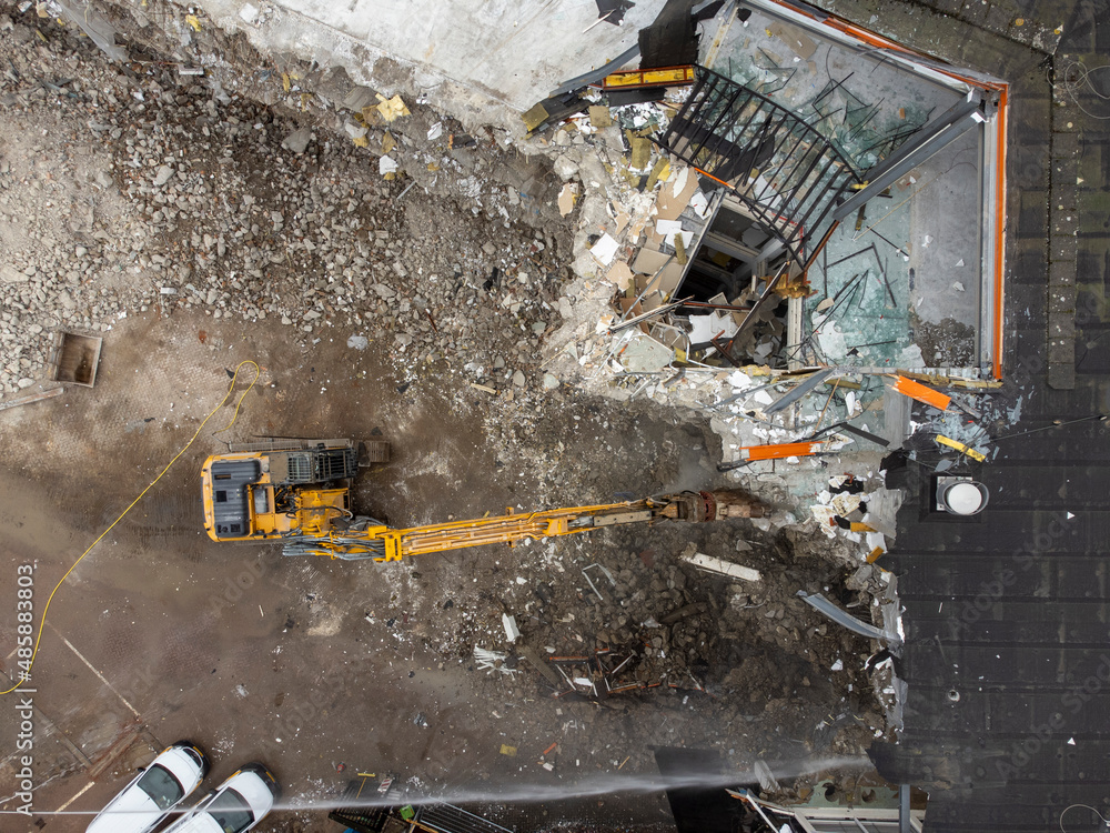 Demolition of a police station using building hydraulic shears, aerial ...