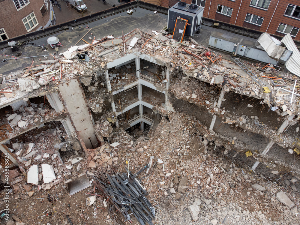 Demolition of a police station using building hydraulic shears, aerial ...