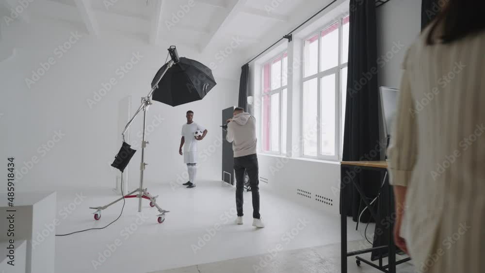 Behind-the-scenes photo shoot: A photographer in a photo studio uses a ...