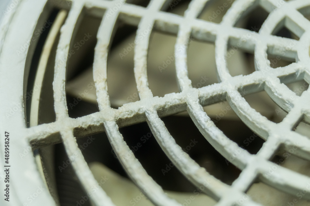 Damaged grille of an old fan in the cooling system of a household ...