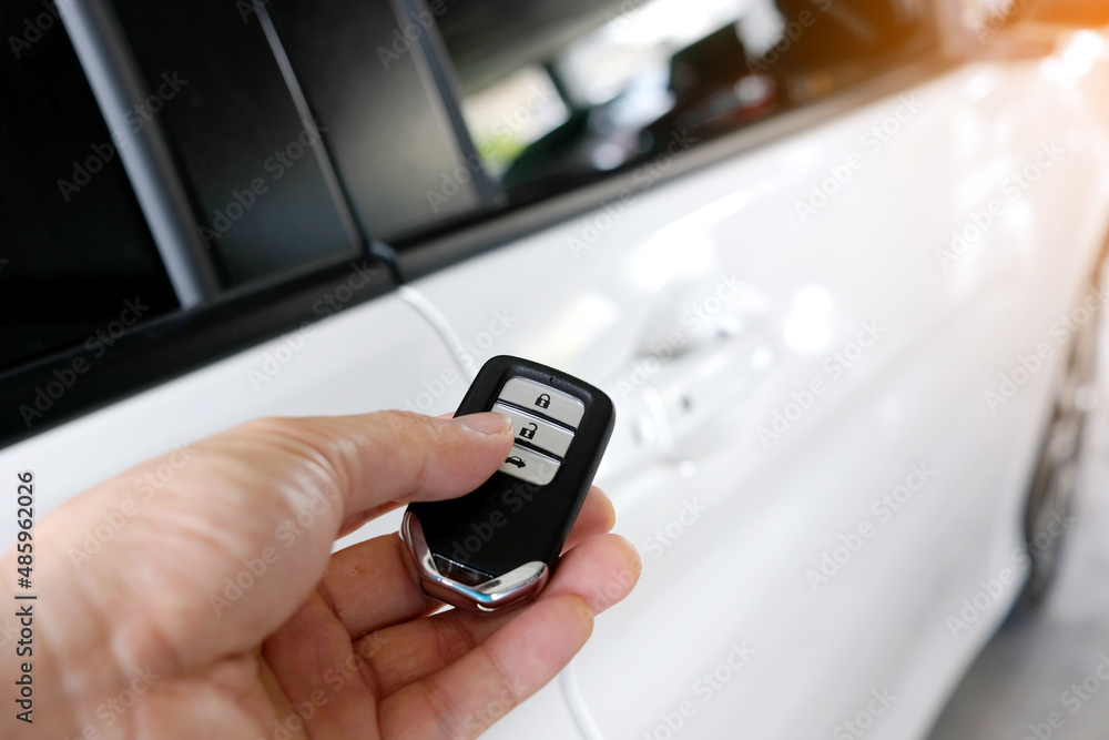 The man in the hand held the remote control of the car, he opened the ...