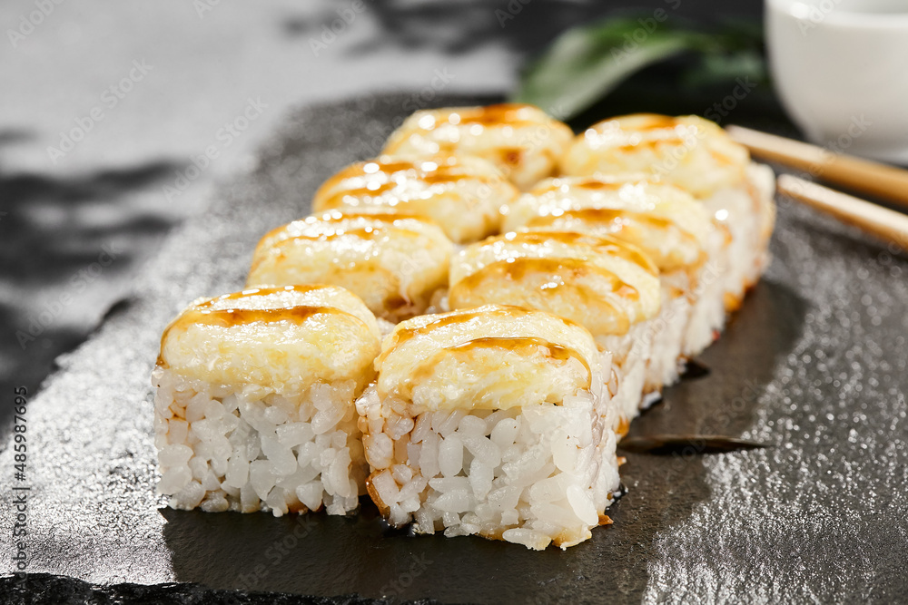 Baked Maki sushi on dark slate. Hot cheese maki with unagi sauce. Sushi ...