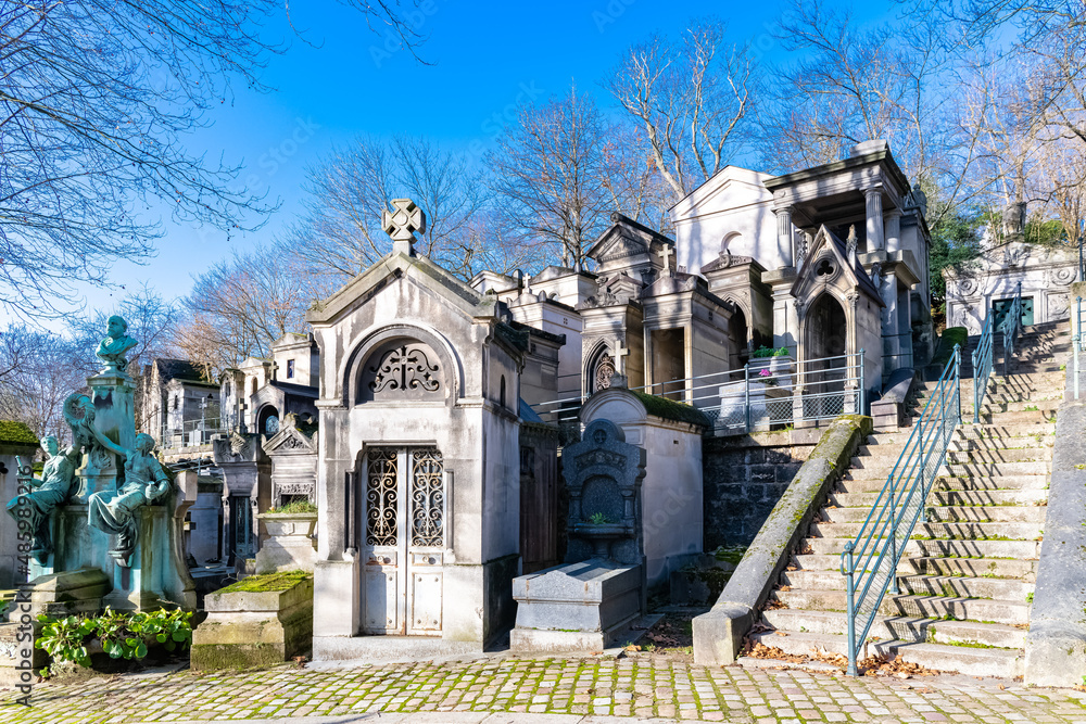 Paris, the Pere-Lachaise cemetery, cobbled alley with graves in winter ...
