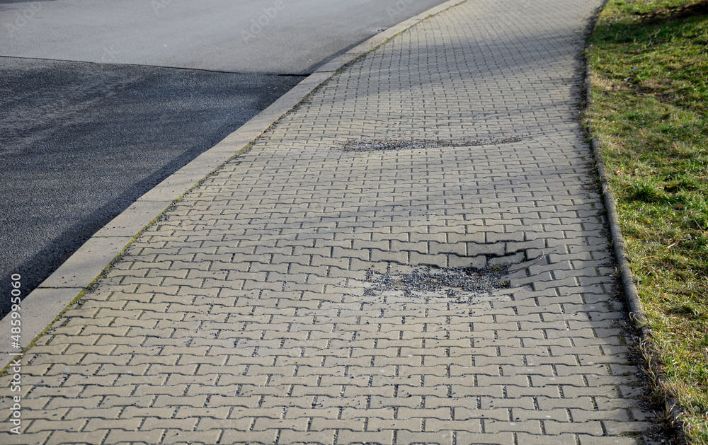 dips and sidewalk ripple. damage to surface of concrete tiles caused by ...