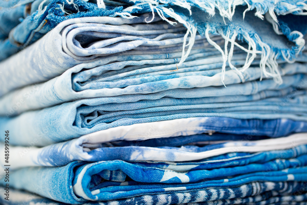 Stack of jeans neatly folded clothes. Denim closeup as background ...