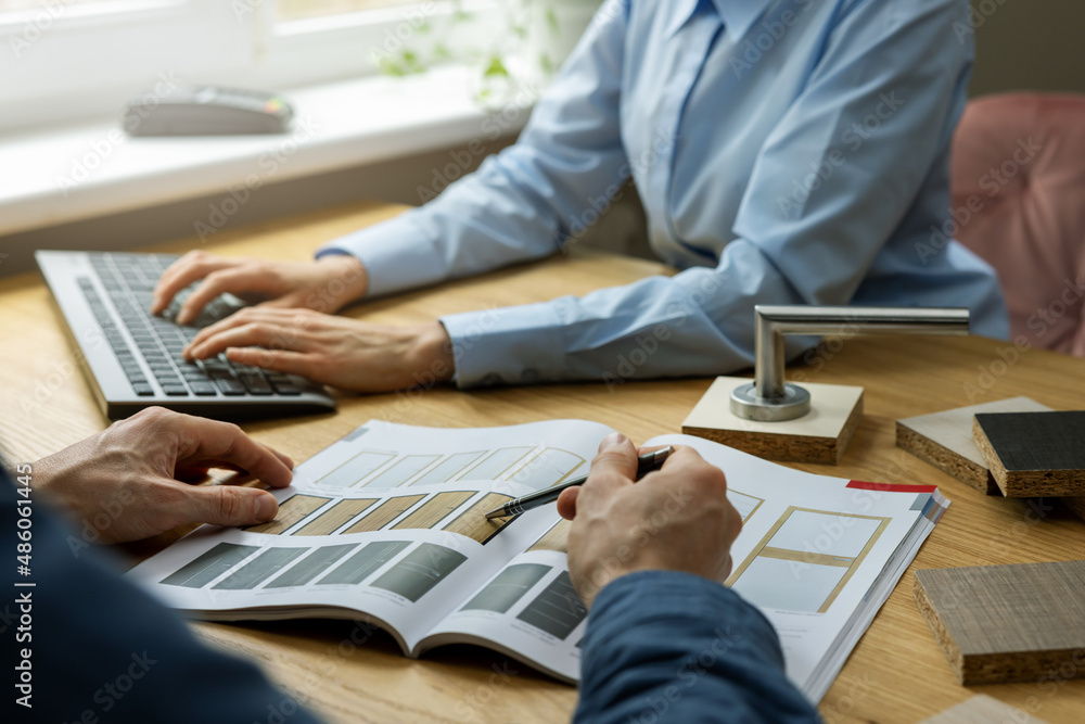 customer choosing door design from product catalogue in door store ...