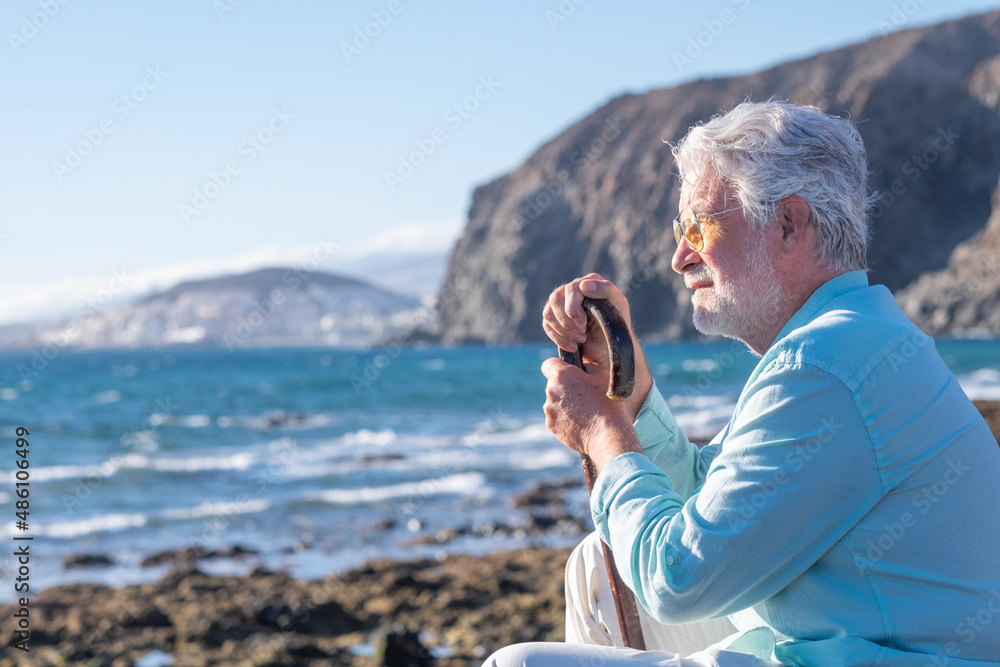 Portrait of pensive mature bearded senior man resting at the beach ...
