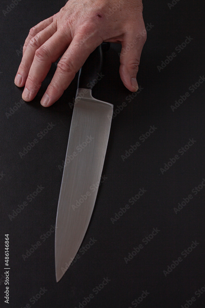 Adult hand reaching for a big knife. Threat concept photo of domestic ...