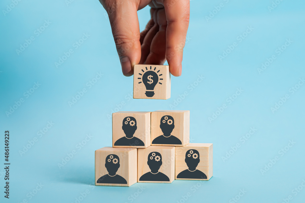 Concept creative idea and innovation. Hand picked wooden cube block with head human symbol and ...